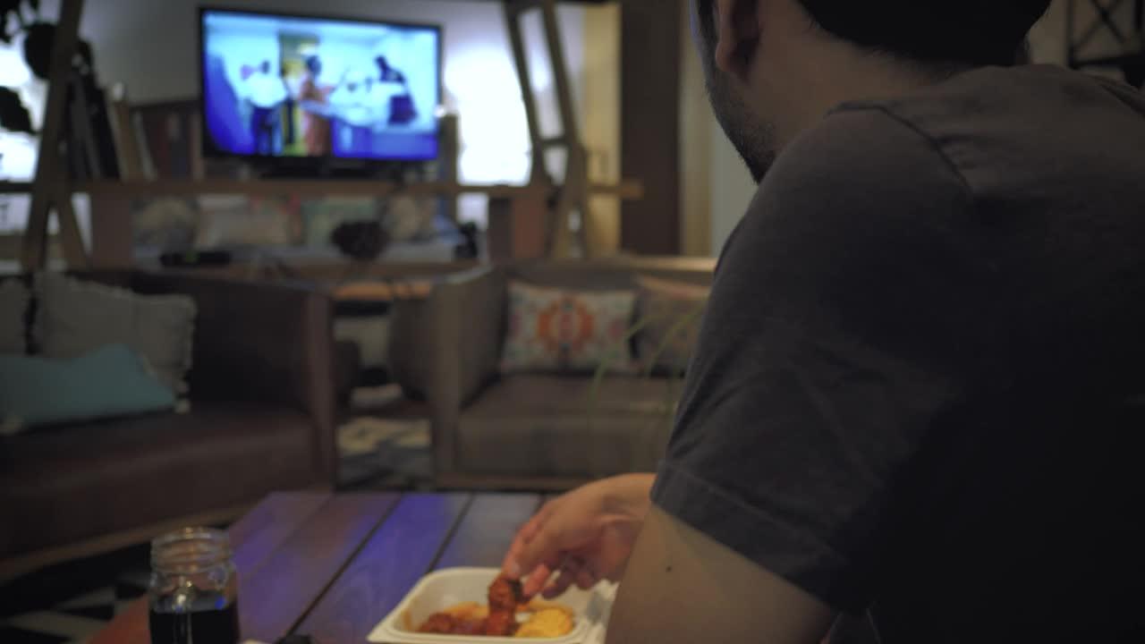 Young man eating while watching television - One News Page VIDEO